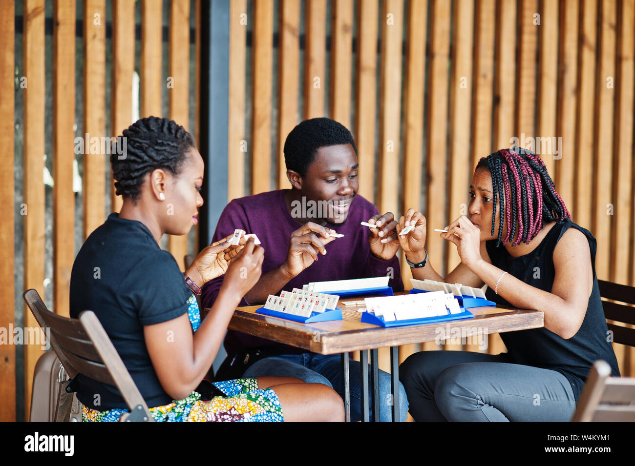 Group of three african american friends play table games Stock Photo ...