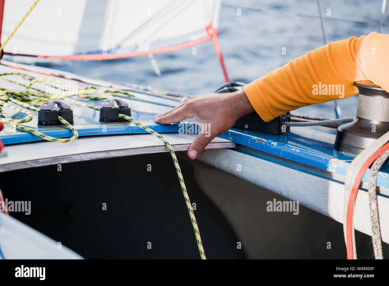 Man's hand with boat rope. Yachtsman moors his motor boat at jetty ...