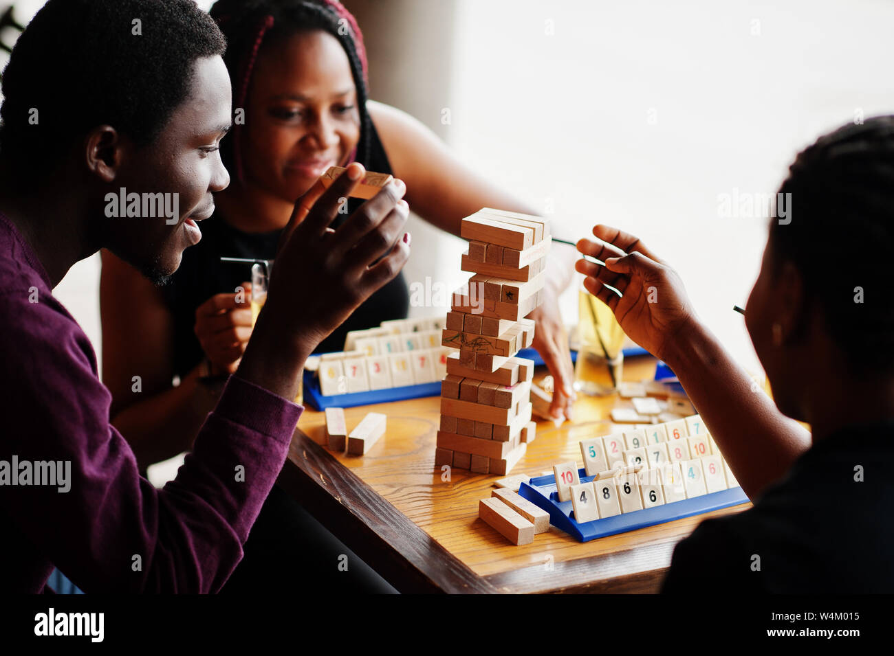 Group of three african american friends play table games Stock Photo ...