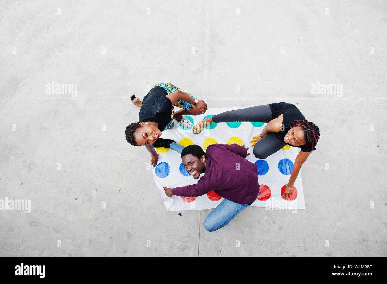 Group of three african american friends play twister game outdoor Stock ...