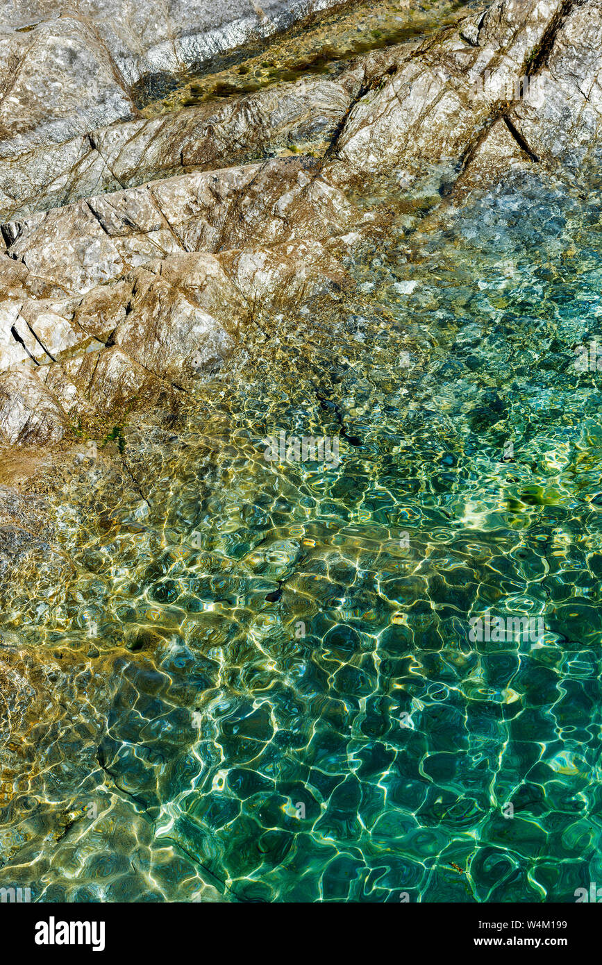 Ripples in the sea flowing around rocks Stock Photo - Alamy