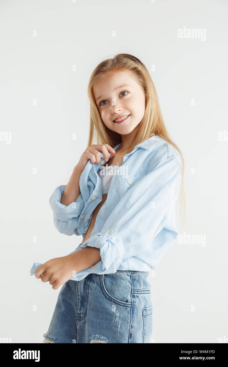 Stylish little smiling girl posing in casual clothes isolated on white ...