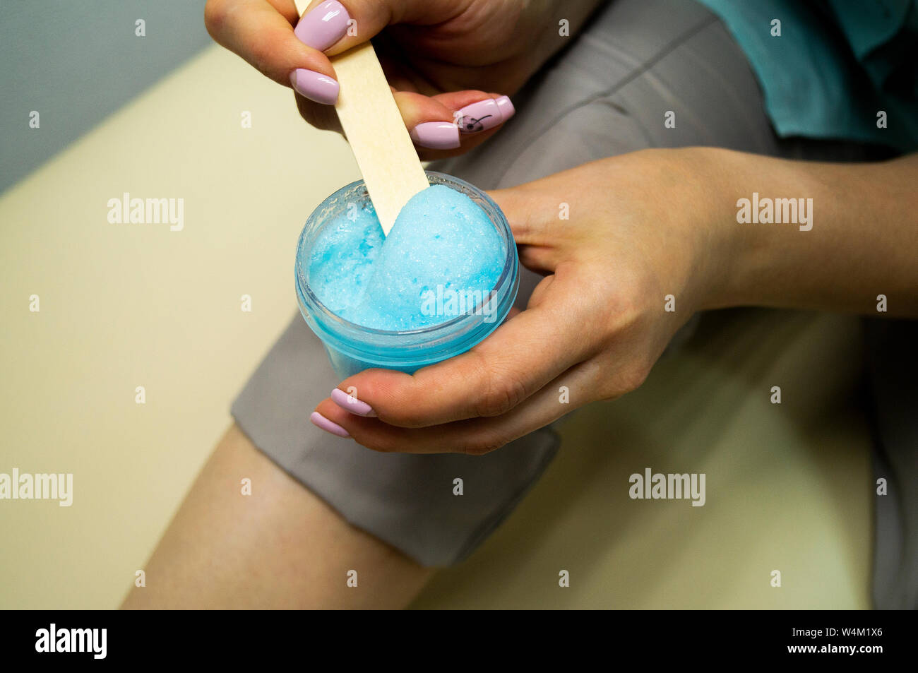 Rejuvenation procedure. The girl puts a blue scrub on her leg Stock ...