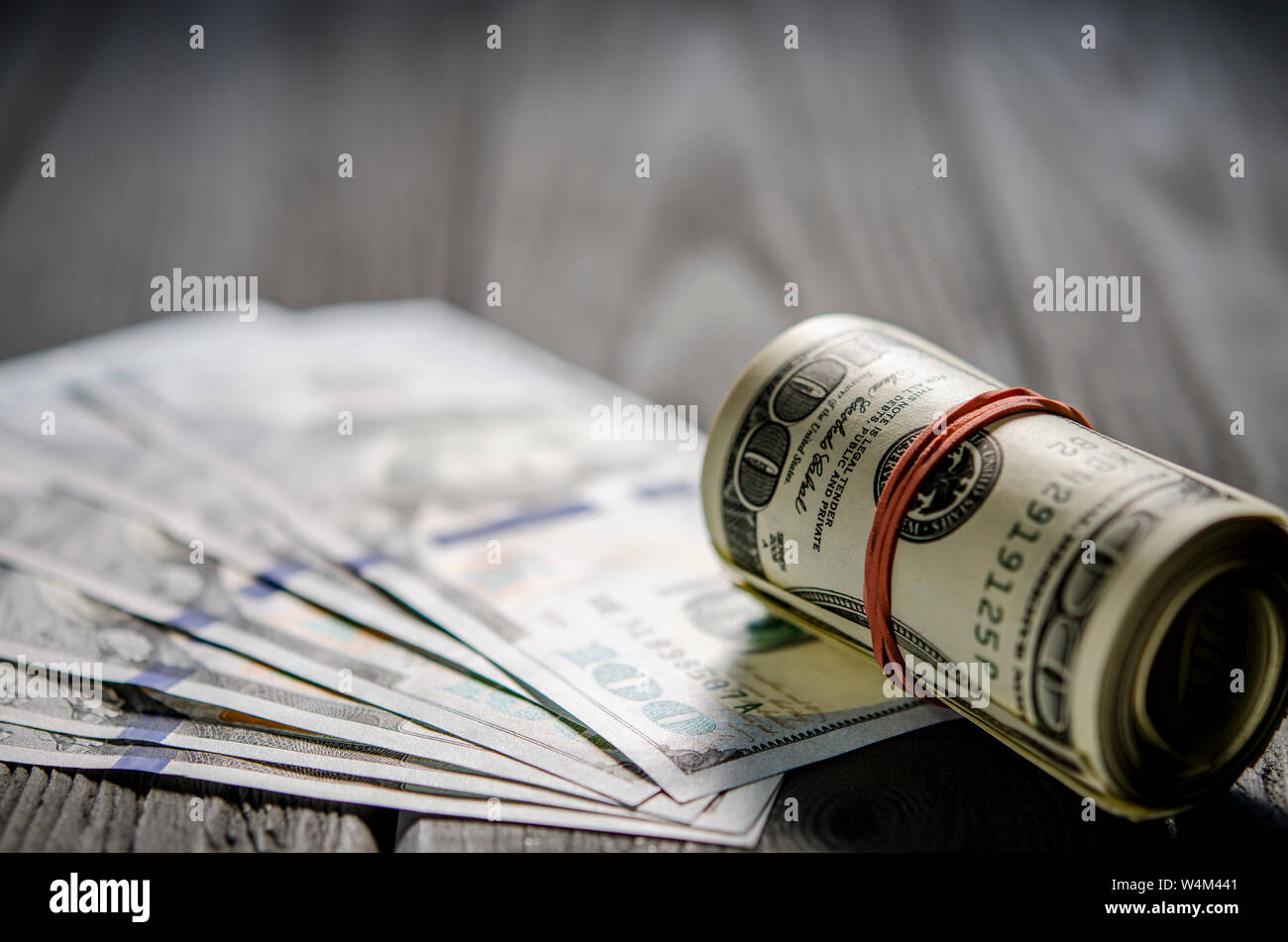 A thick roll of old hundred dollar banknotes tied a red rubber band ...