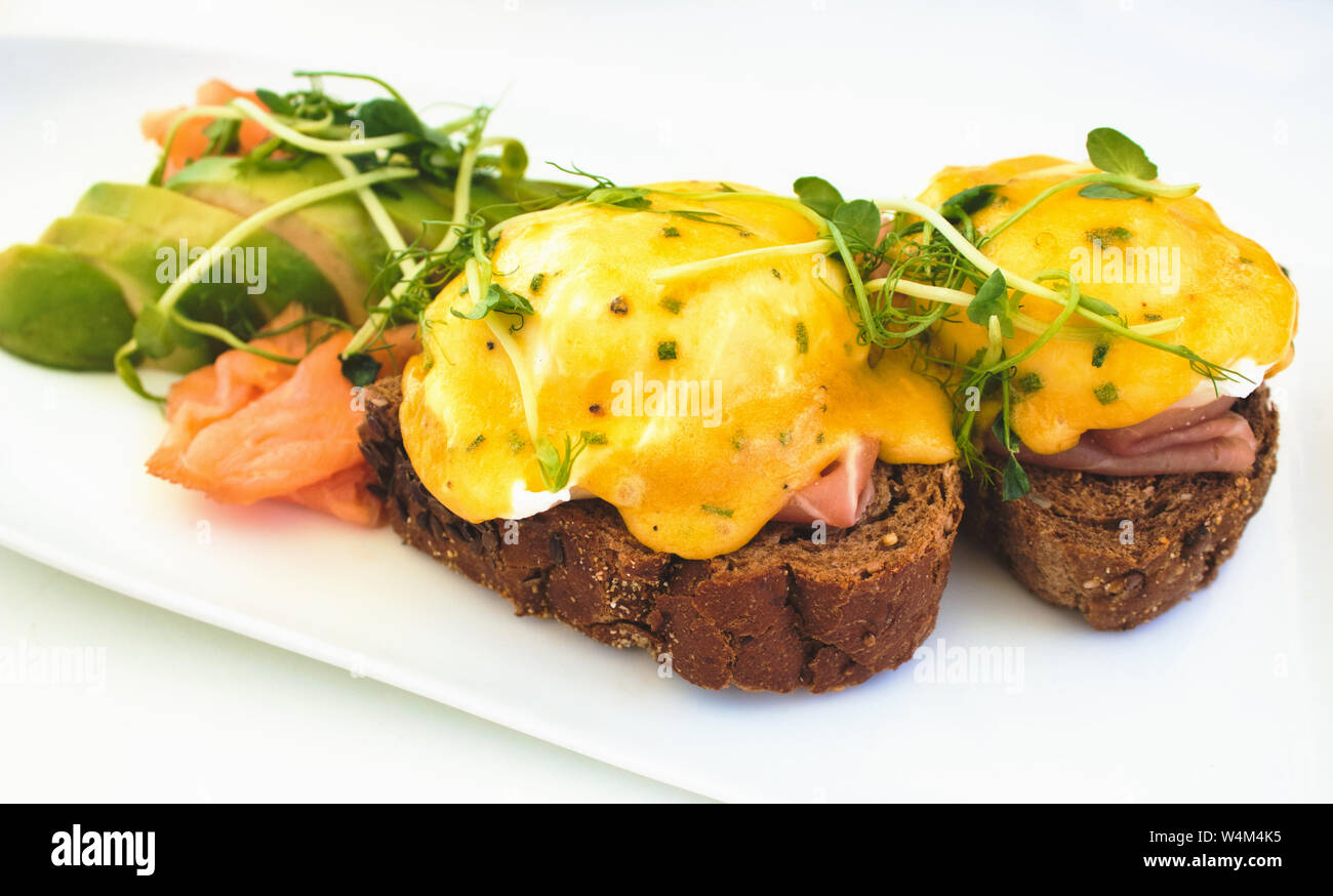 Eggs Benedict on brown bread toast with smoked salmon and sliced ...