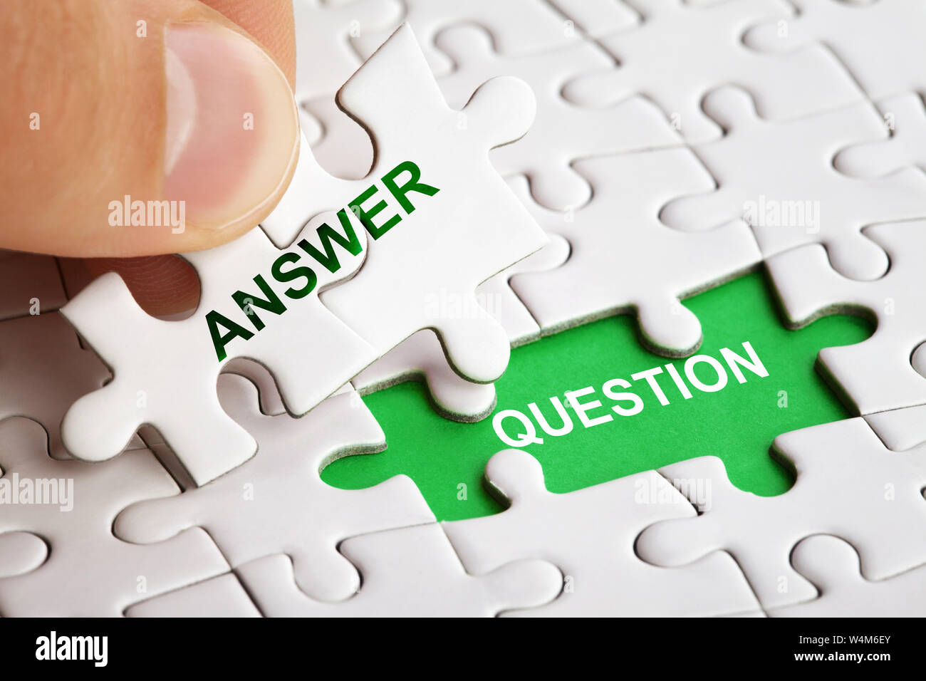 Male hand and missing puzzle with ANSWER QUESTION WORD Stock Photo - Alamy