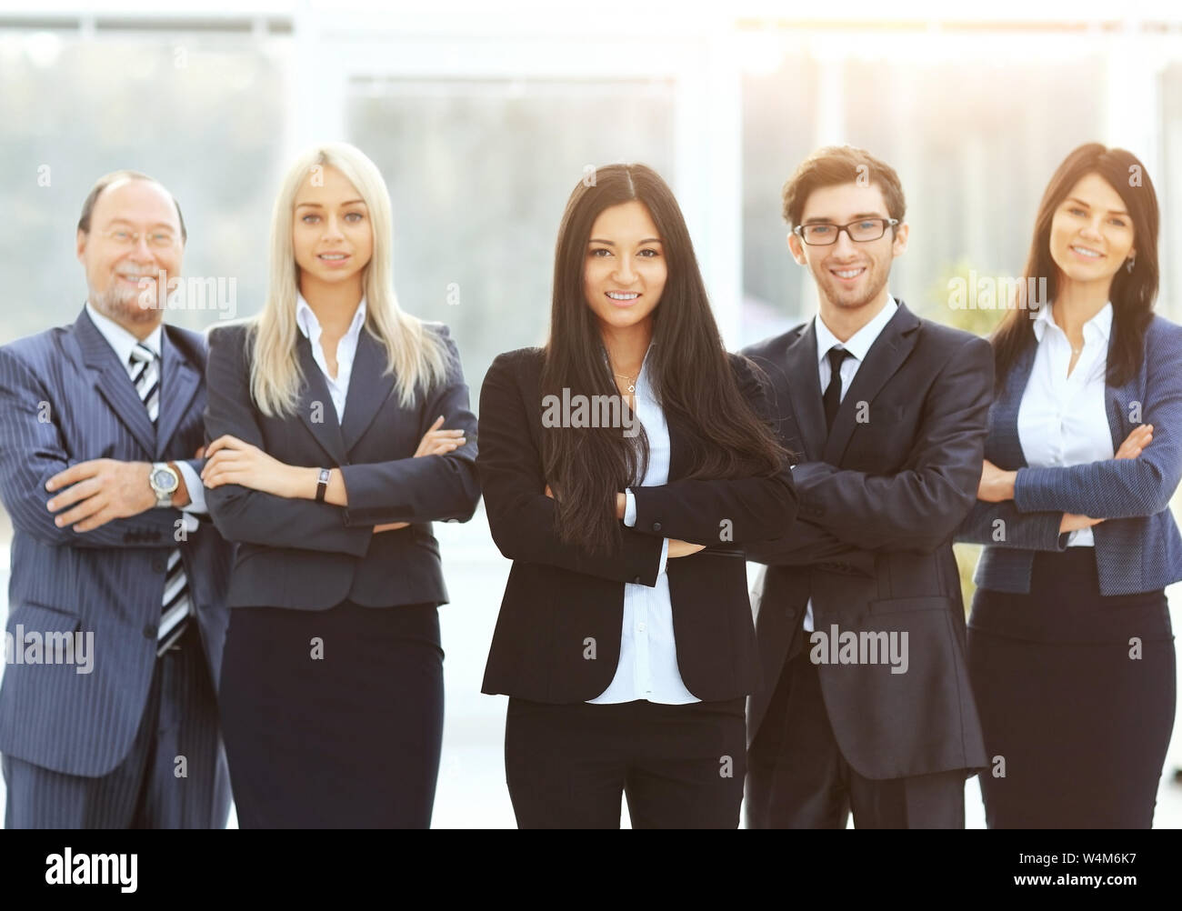 successful and happy business team on office background, headed by a ...