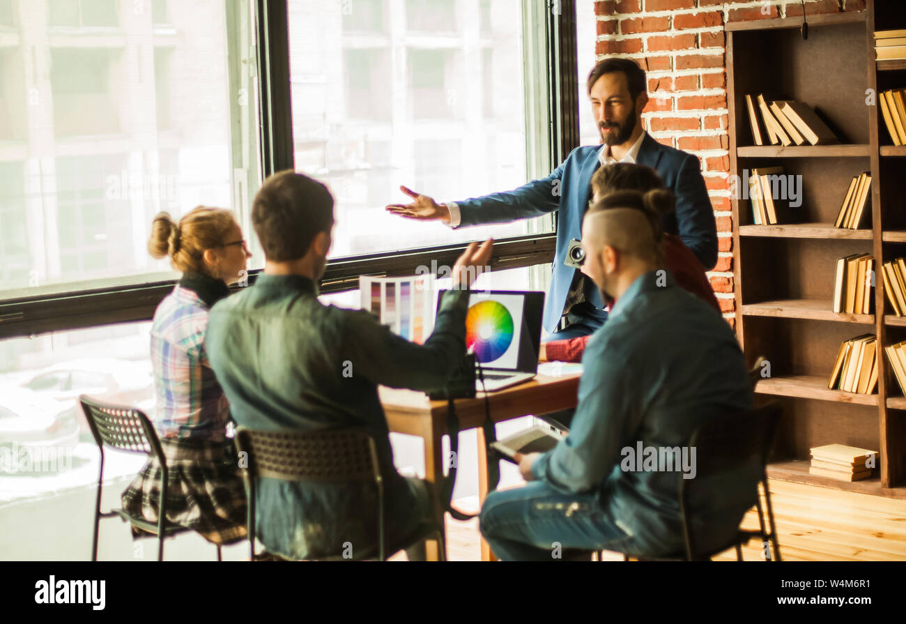 group of creative designers discussing a new color palette in the ...