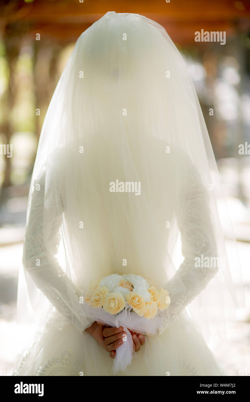 Bride and bridal bouquet. Bride holding her bouquet behind her back ...
