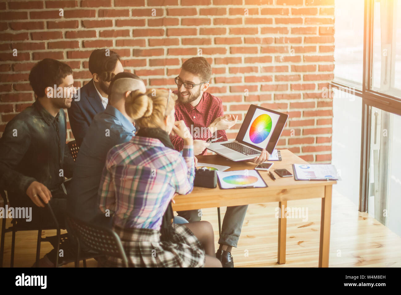team of designers in the workplace in front of the open laptop is ...