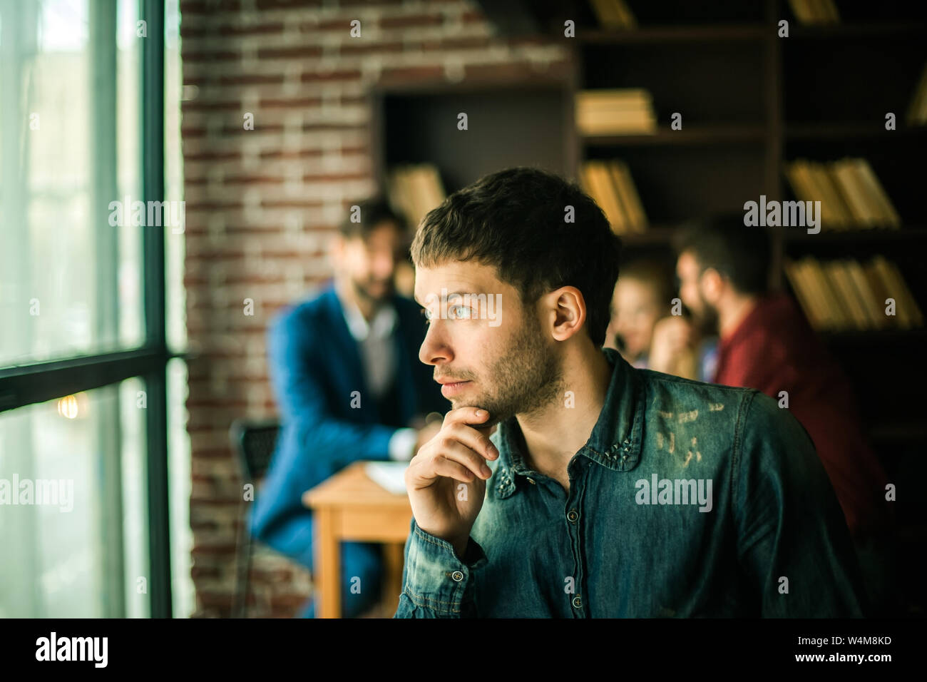 employees are looking out the window at the office on the background of ...