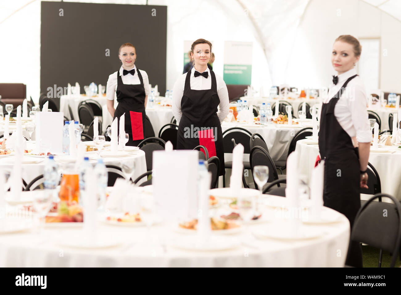 group of waiters at a prestigious restaurant served tables to the ...