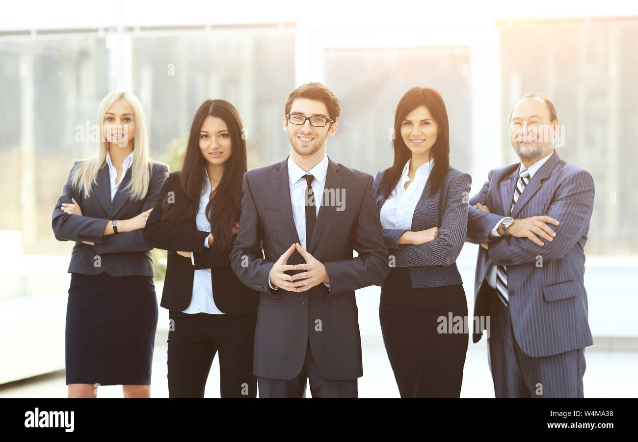 Boss and business team on office background standing in a wedge behind ...