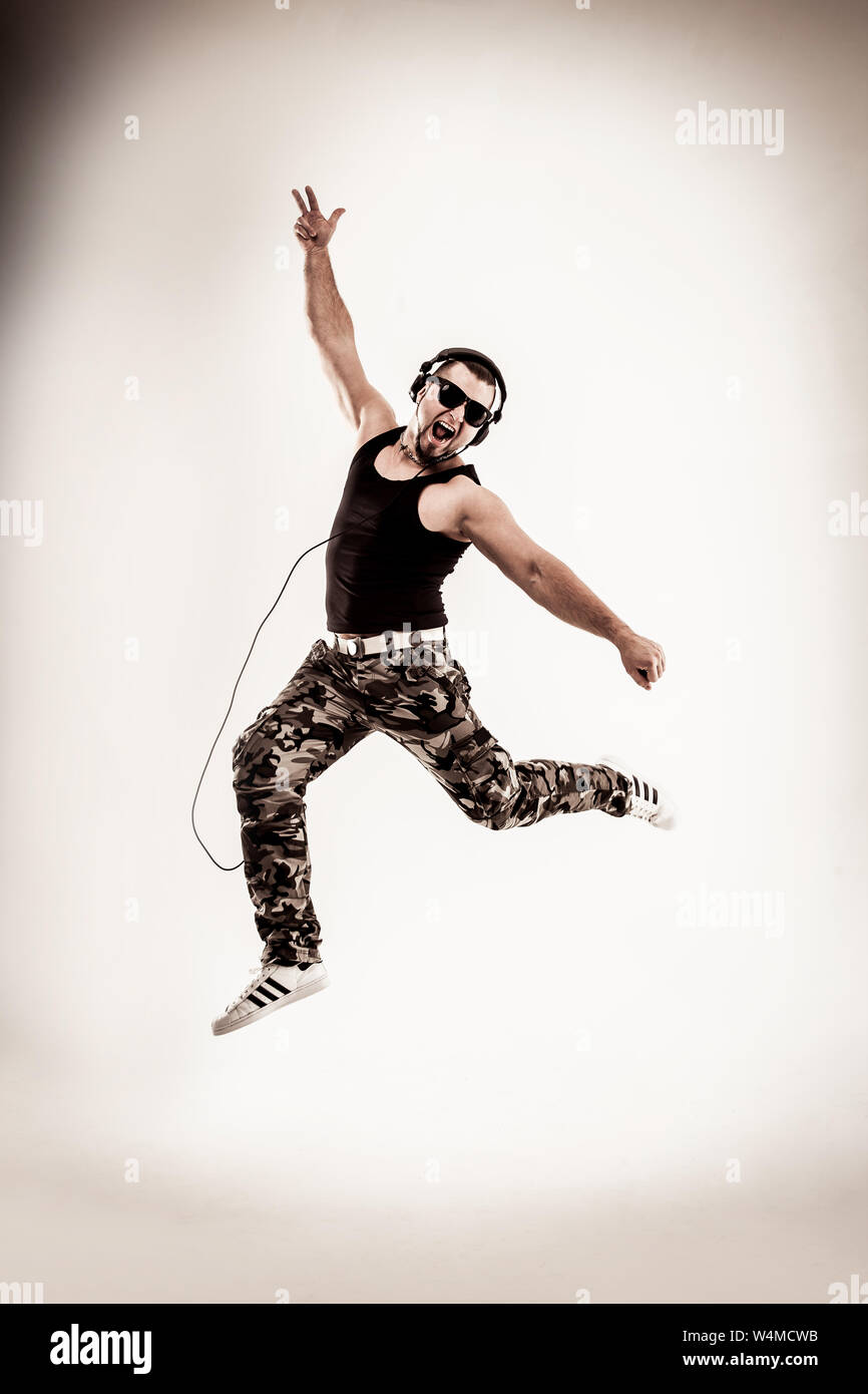 DJ - rapper in headphones takes the rap and break dancing dance on a ...