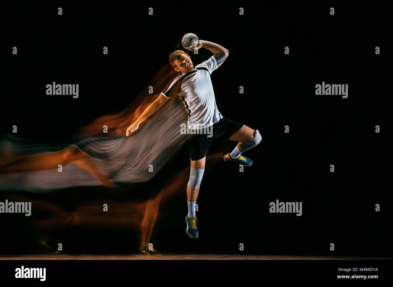 Caucasian young handball player in action and motion in mixed lights ...