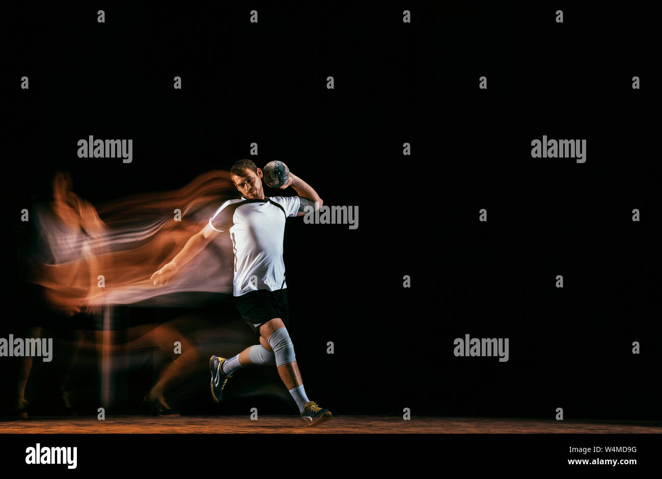 Caucasian young handball player in action and motion in mixed lights ...