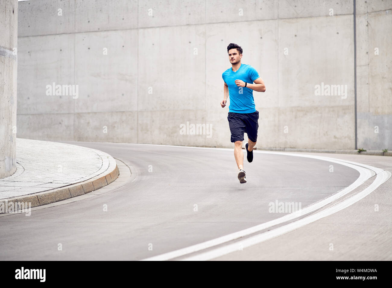Health and fitness concept. Muscular man jogging in the city during ...