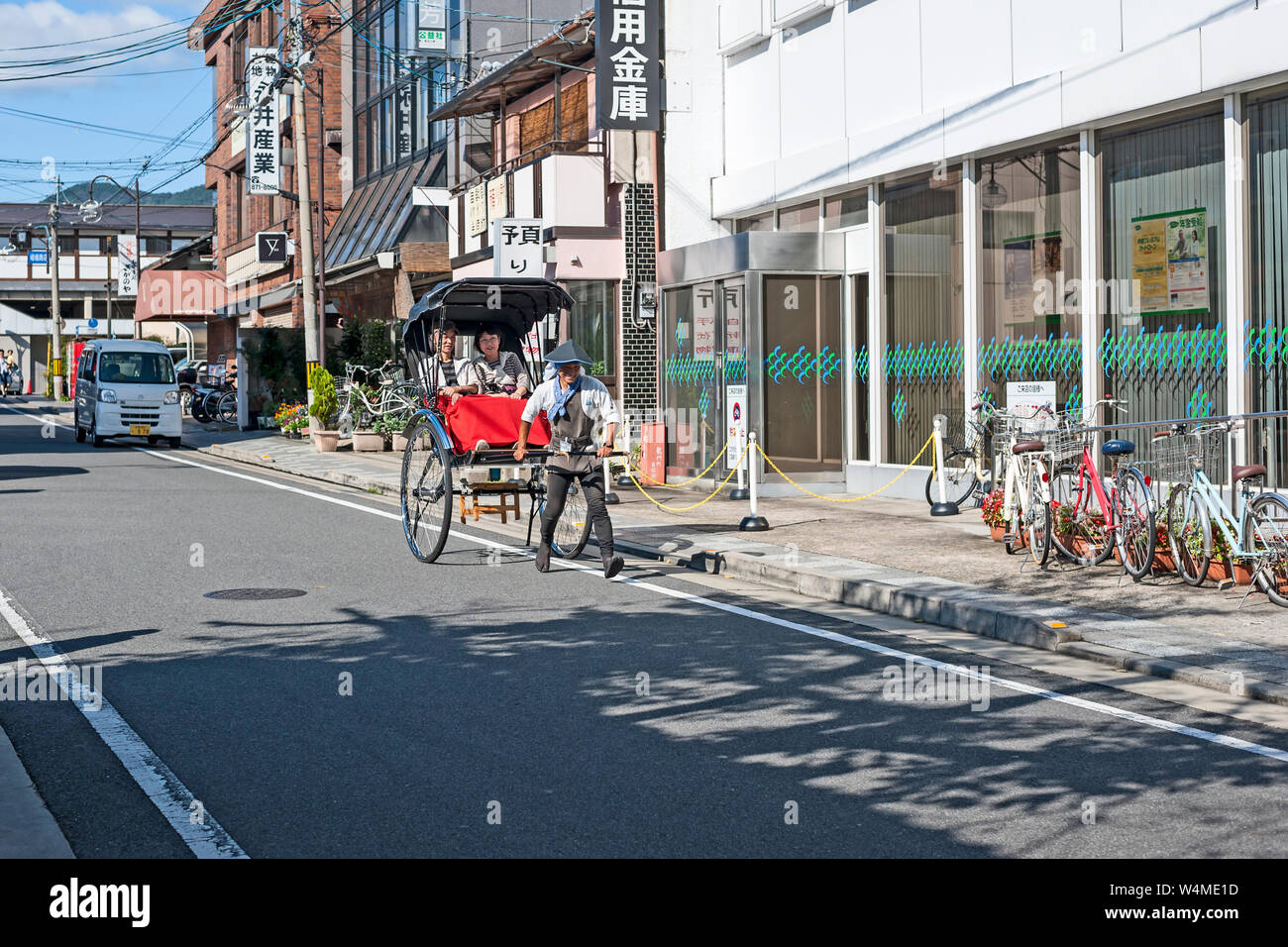 Pulled rickshaw travelling along street in Arashiyama, Japan with two ...