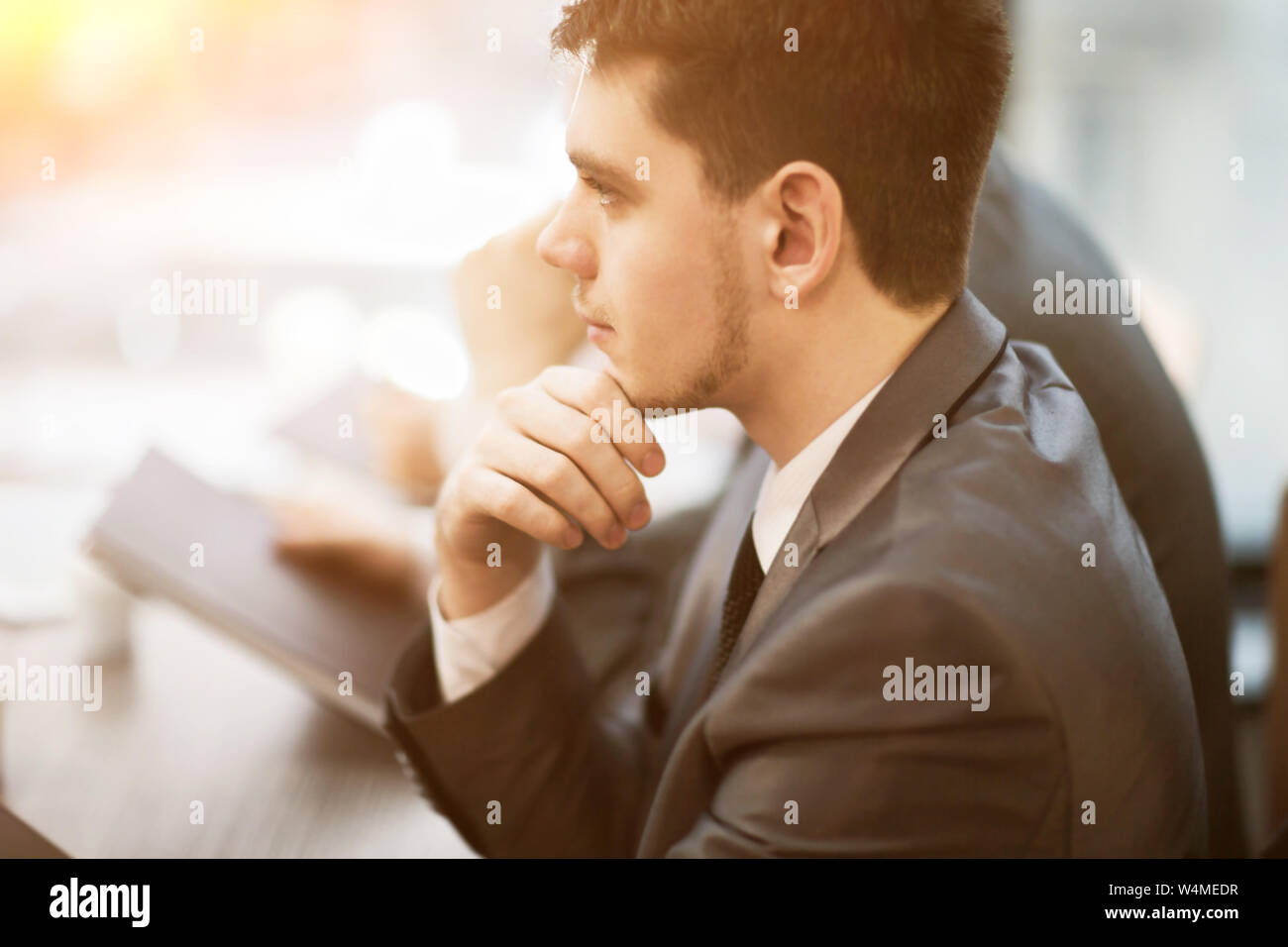 Casual businessman thinking with team behind him in the office Stock ...