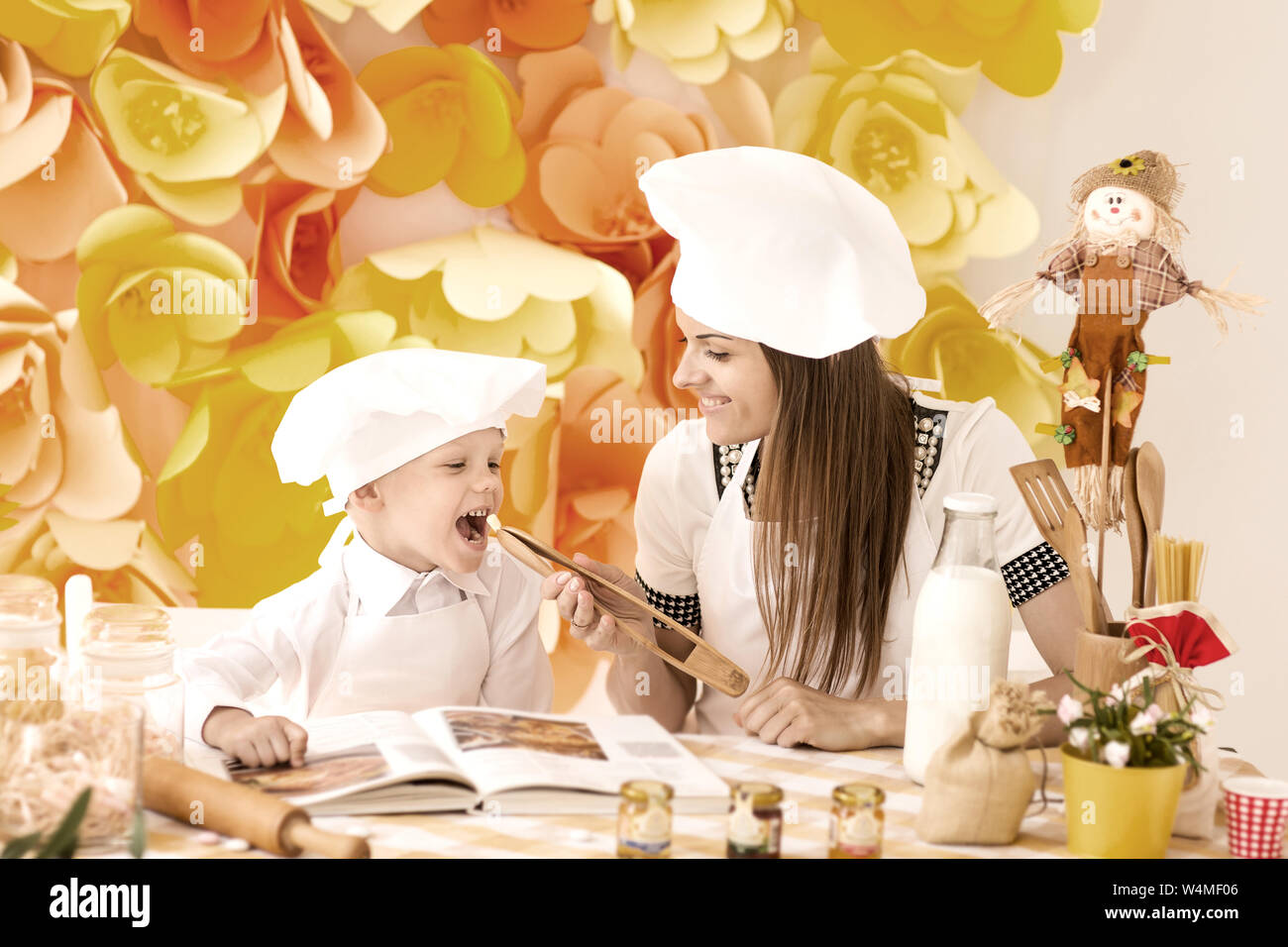A happy mother and her child in the form of cooks prepare a delicious ...