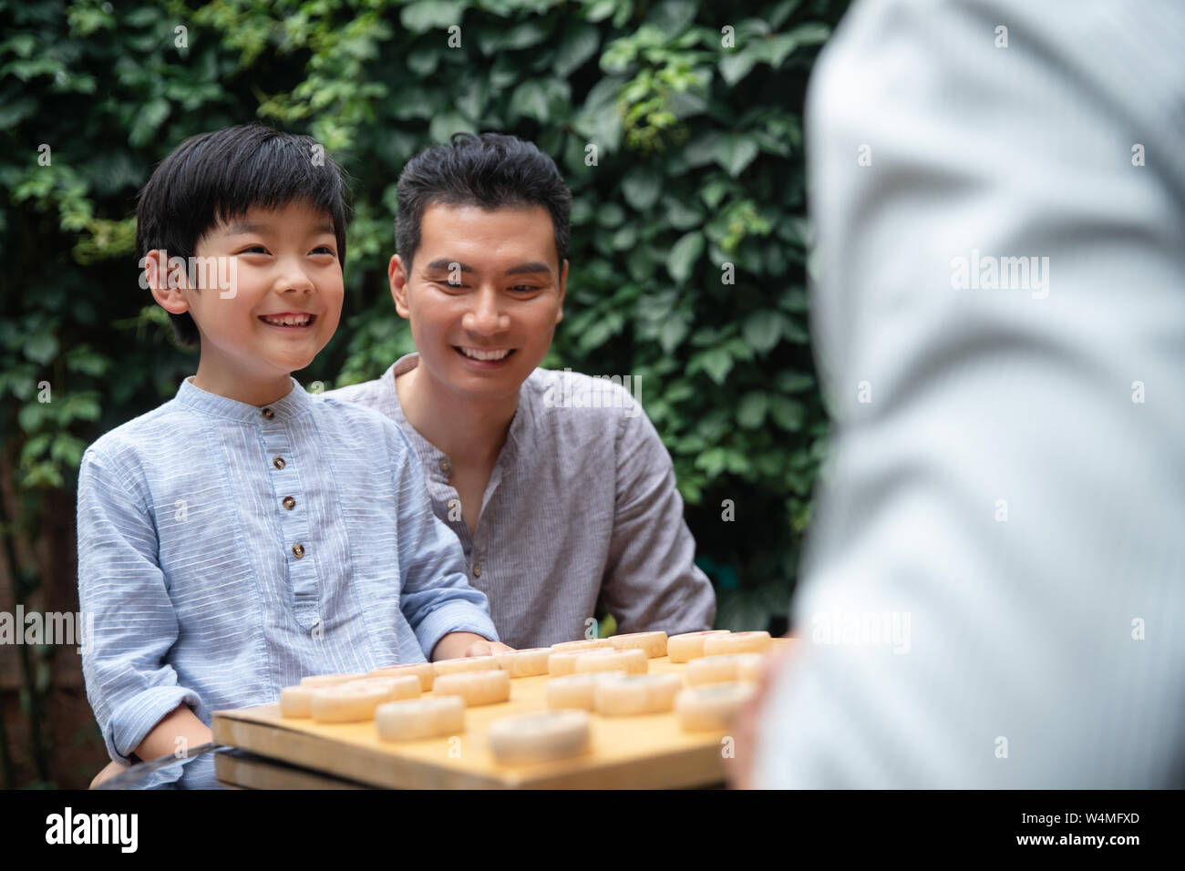 Three people playing chess between the two generations Stock Photo - Alamy
