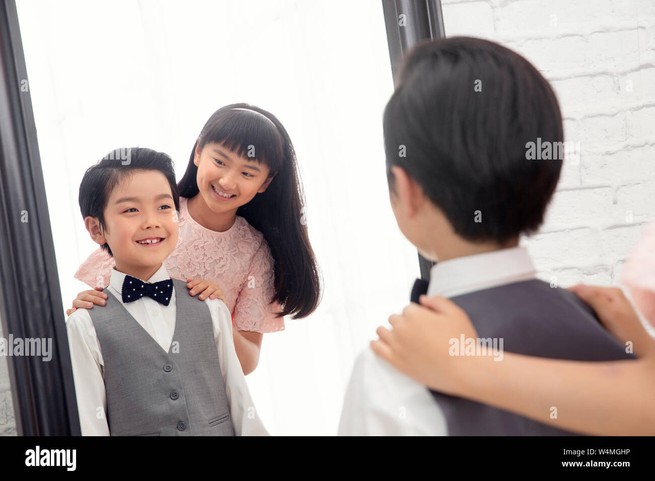 Sister help my brother finish clothes Stock Photo - Alamy