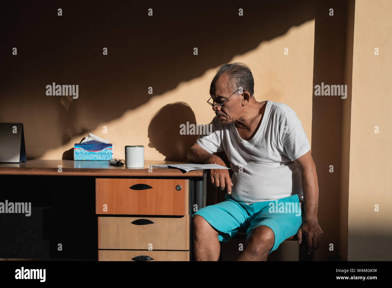 Relaxed asian old man sitting side a table Stock Photo - Alamy