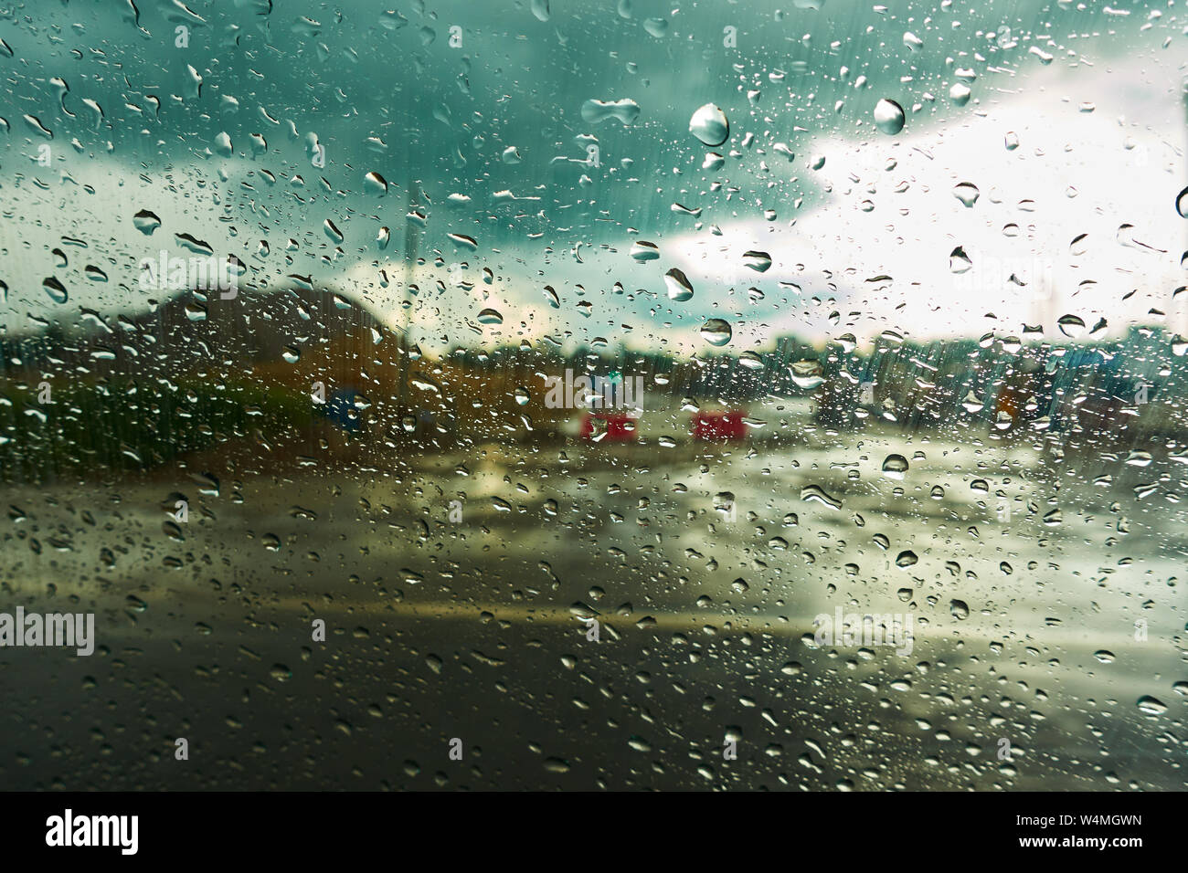 Blurred background with rain drops on car glass. Riding in the rain ...