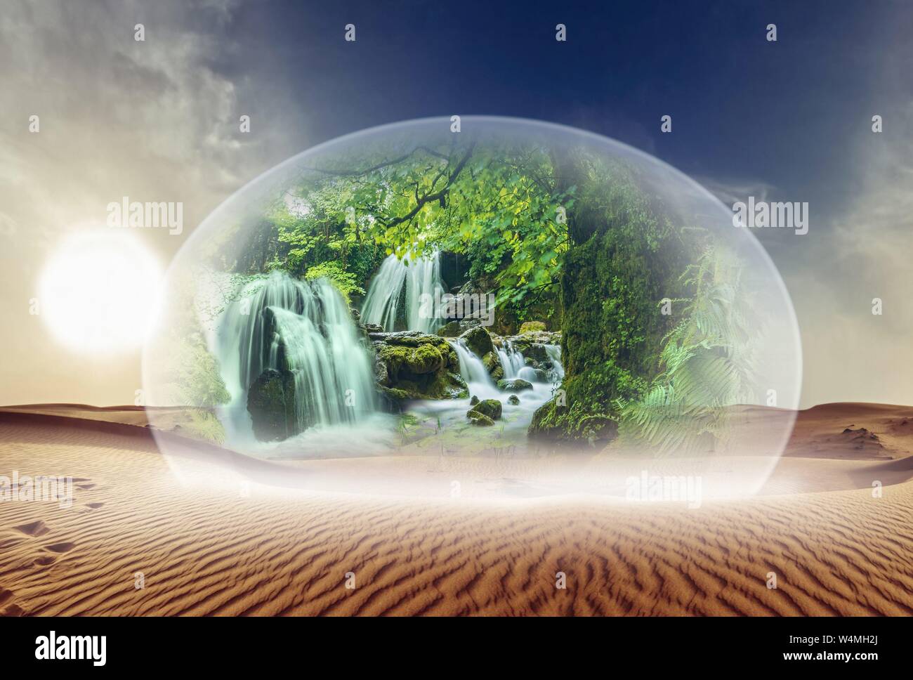 Glass dome with natural scenery and waterfalls in a desert landscape ...