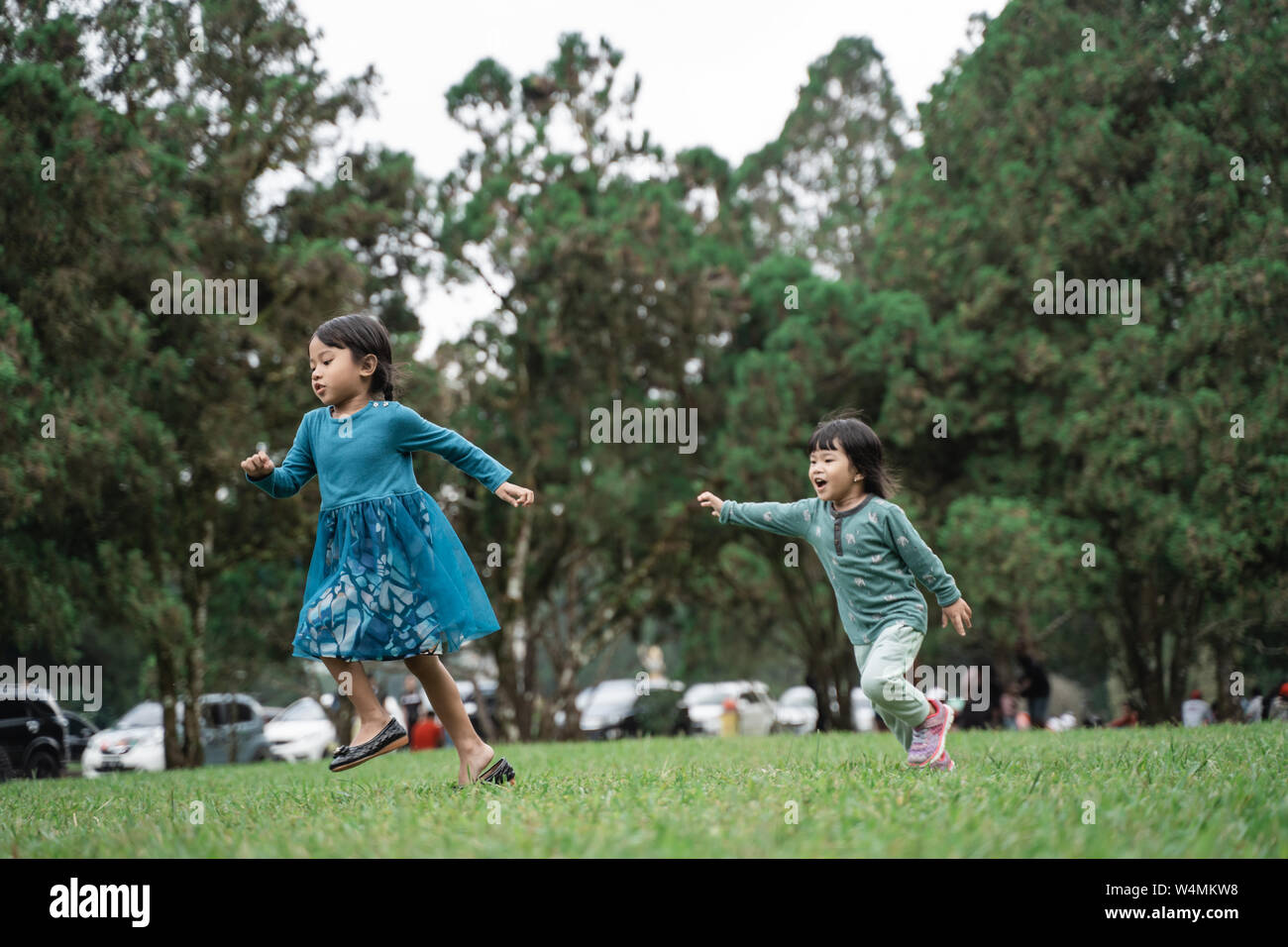 two little girls playing chase each other Stock Photo - Alamy