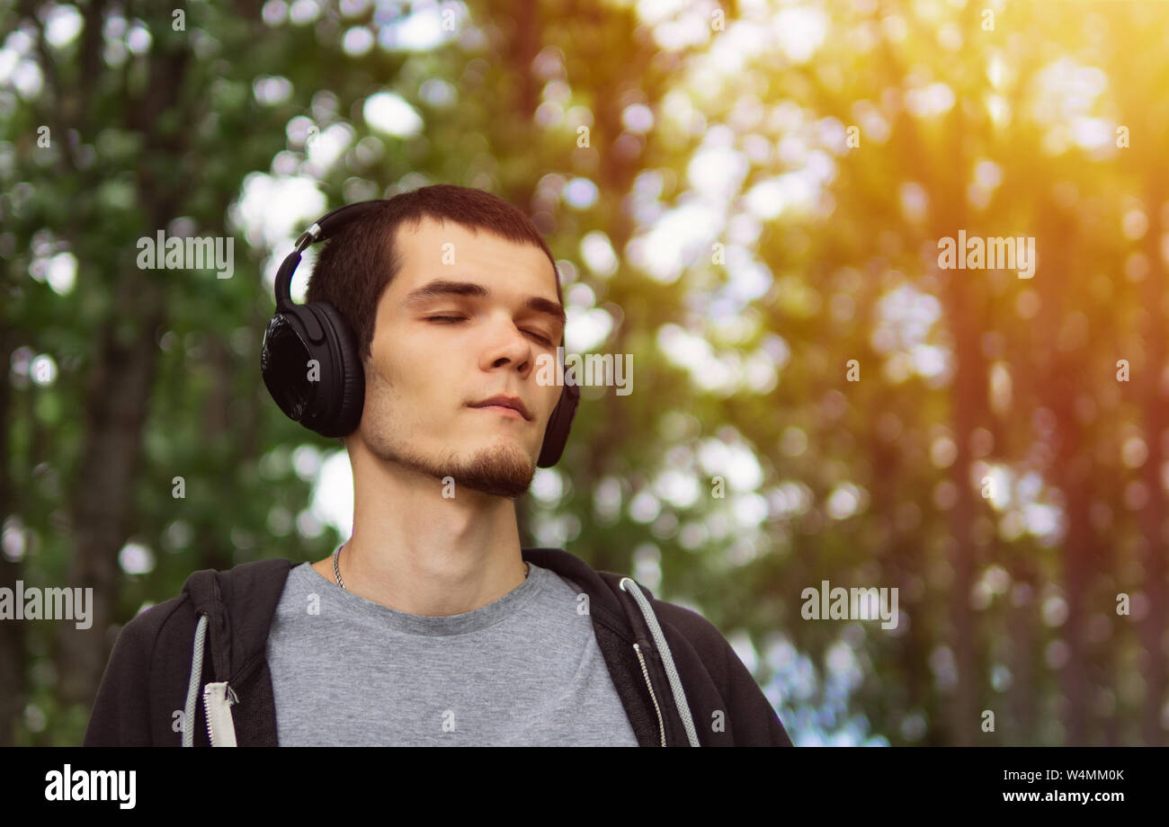 Beautiful man in headphones listening to music outdoor Stock Photo - Alamy