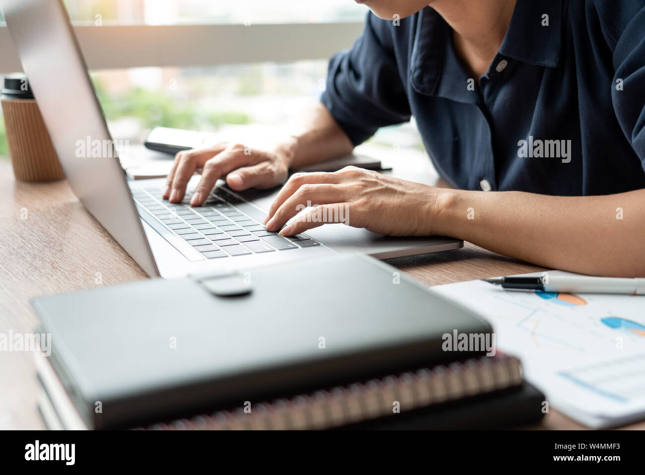 Business man working with graph data in laptop and documents on his ...
