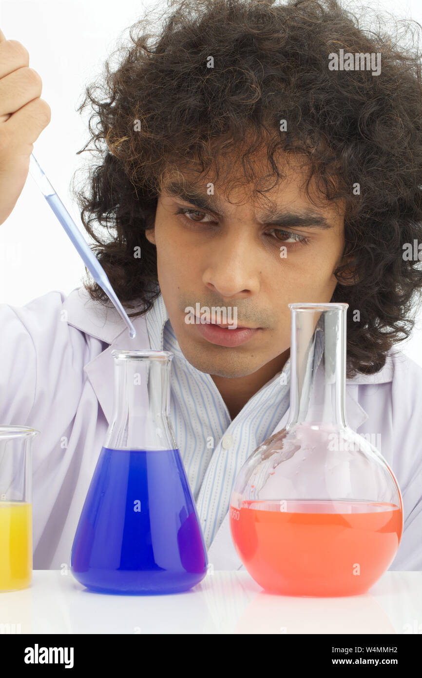 Scientist dripping liquid into a flask Stock Photo - Alamy