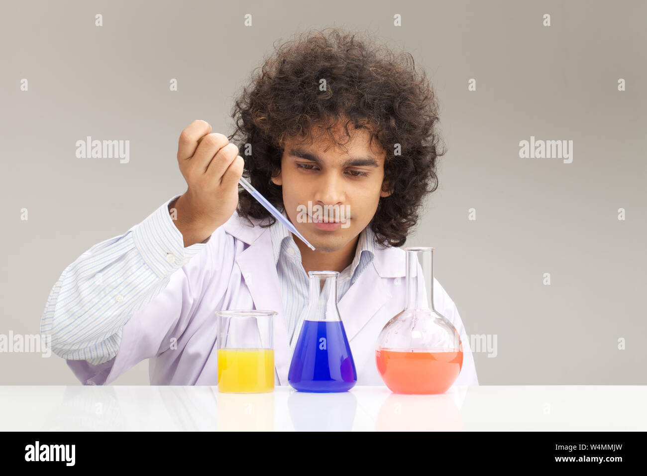 Scientist dripping liquid into a flask Stock Photo - Alamy