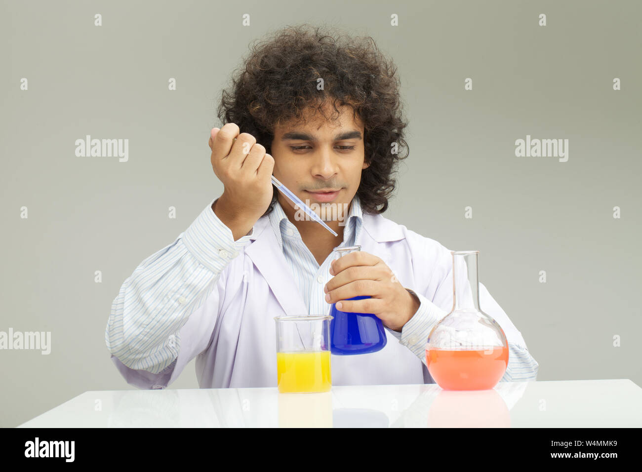 Scientist dripping liquid into a flask Stock Photo - Alamy