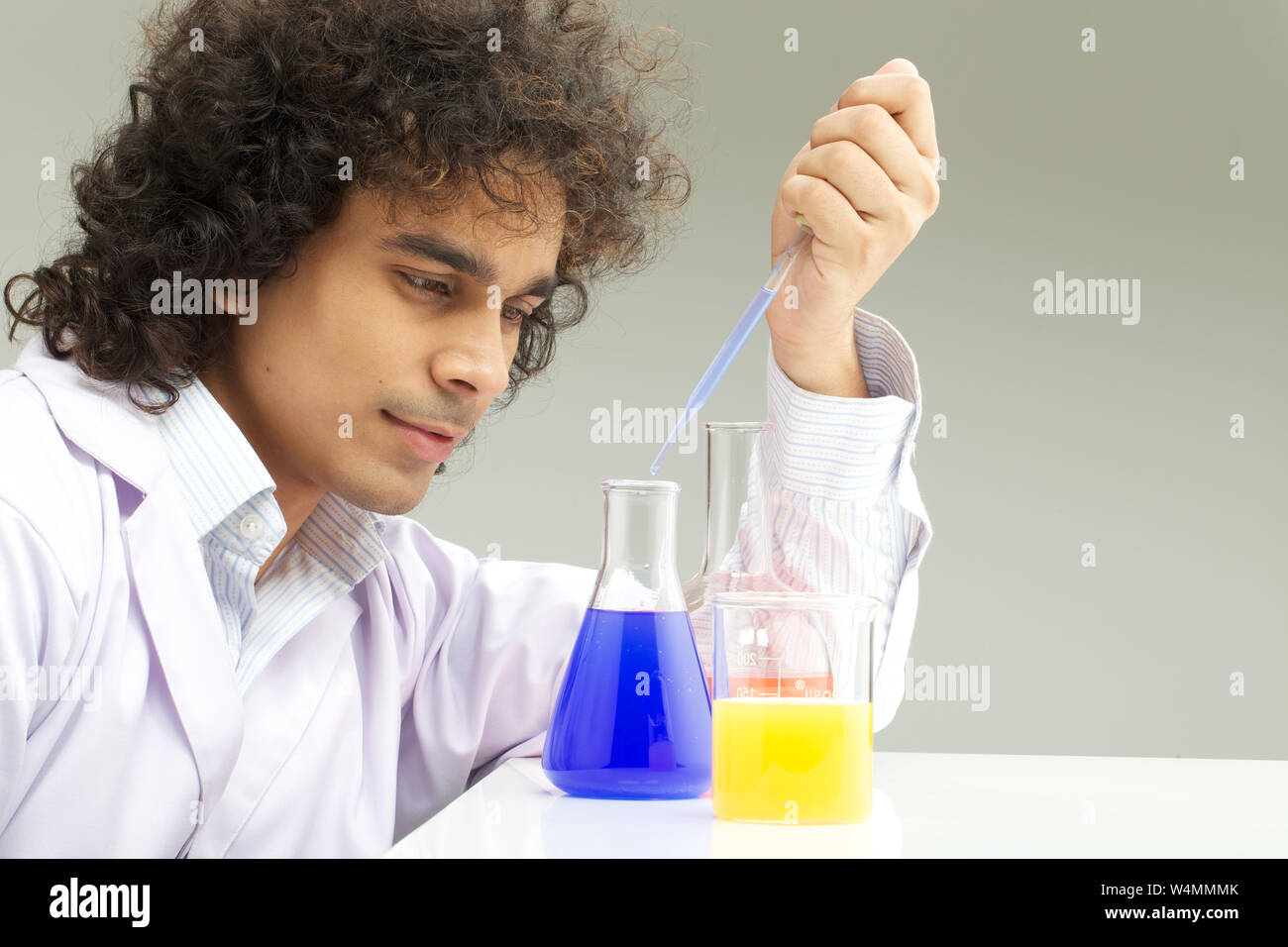 Scientist dripping liquid into a flask Stock Photo - Alamy