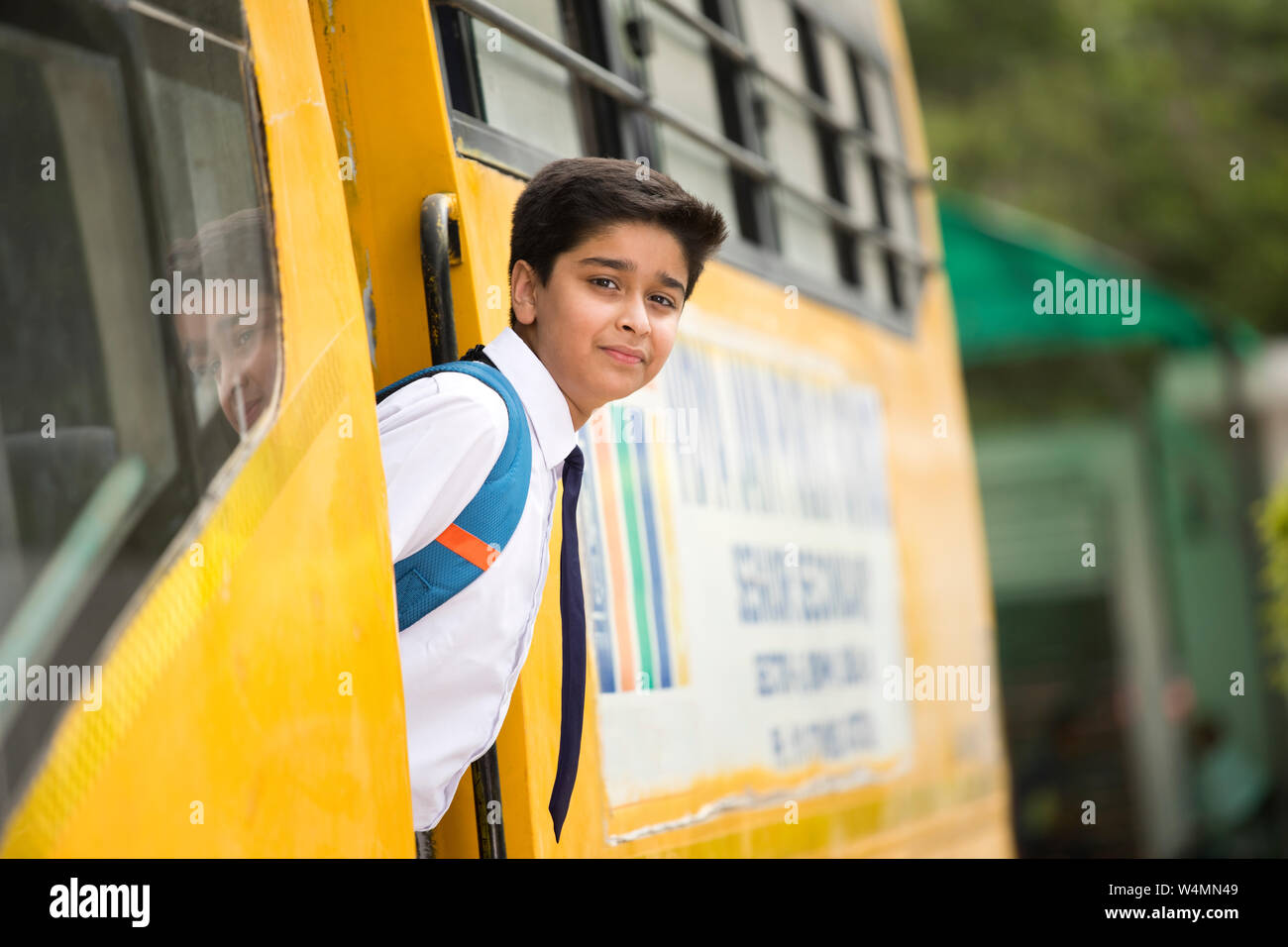Indian schoolboy getting into the school bus looking outside Stock ...