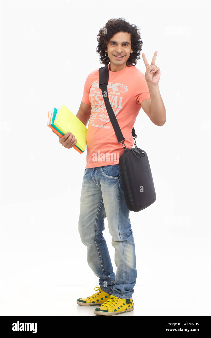 College boy showing V sign and smiling Stock Photo - Alamy