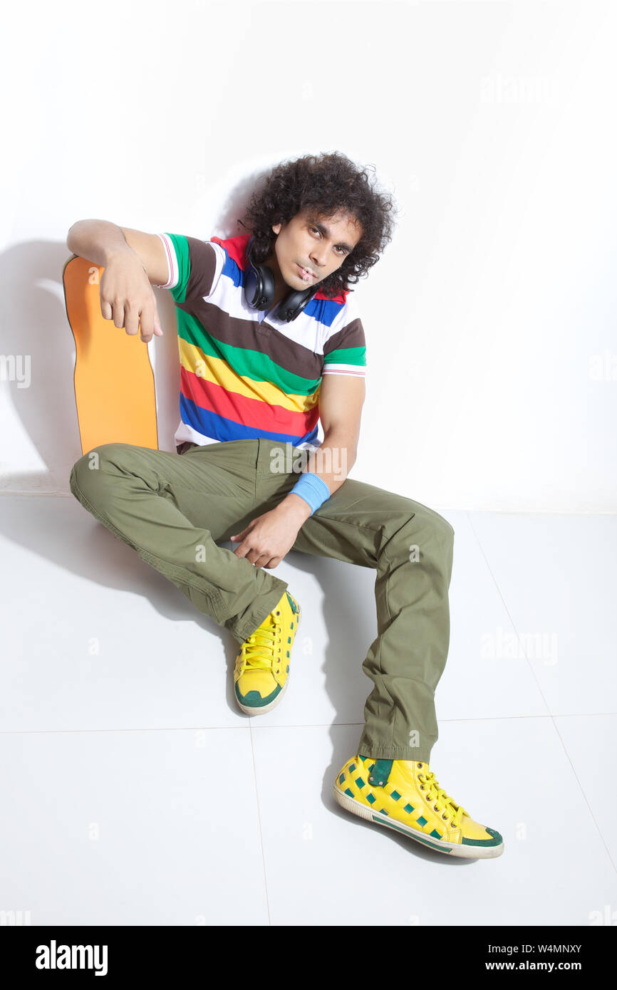 High angle view of a man sitting on floor with skateboard Stock Photo ...