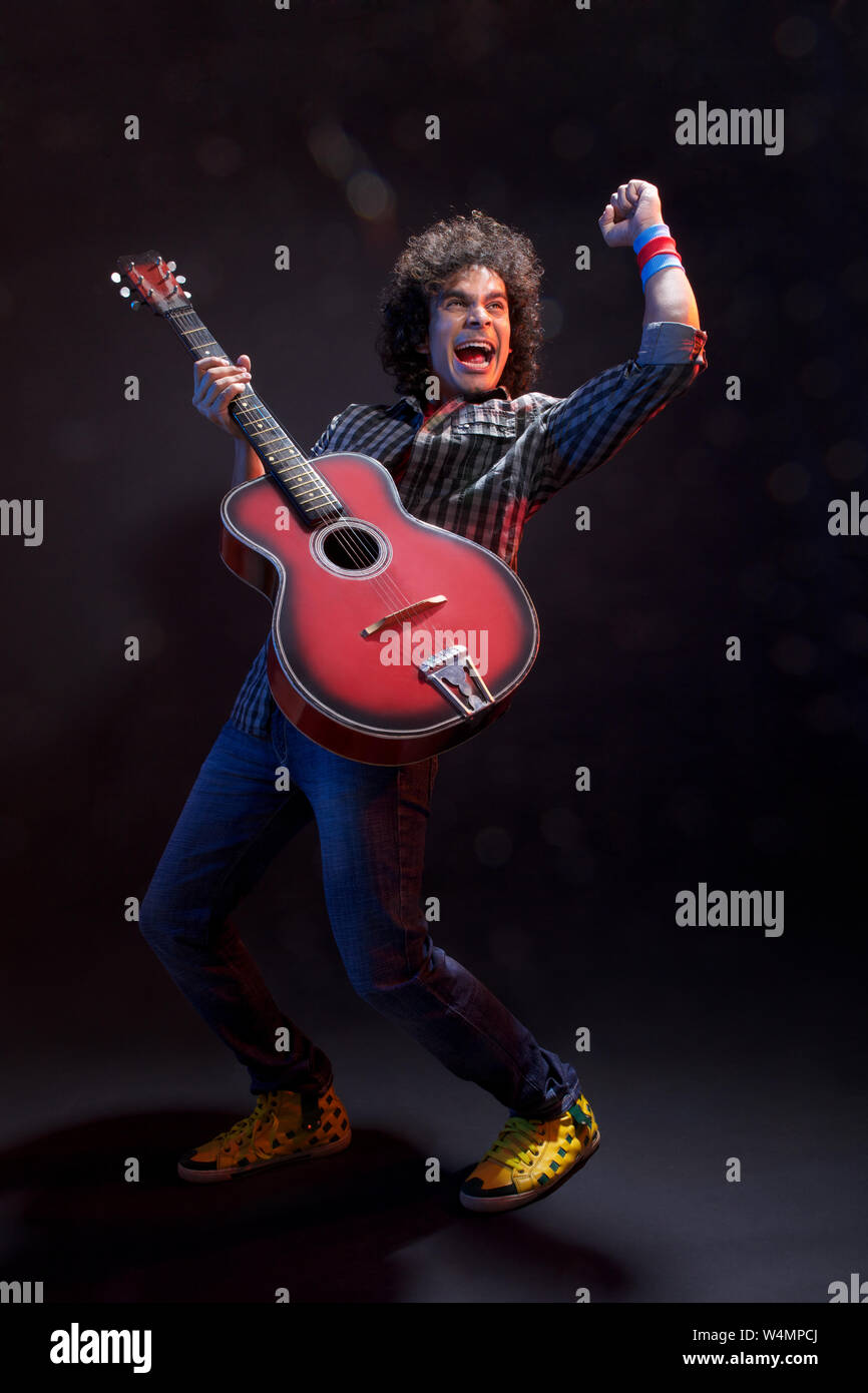 Man playing a guitar and punching the air Stock Photo - Alamy