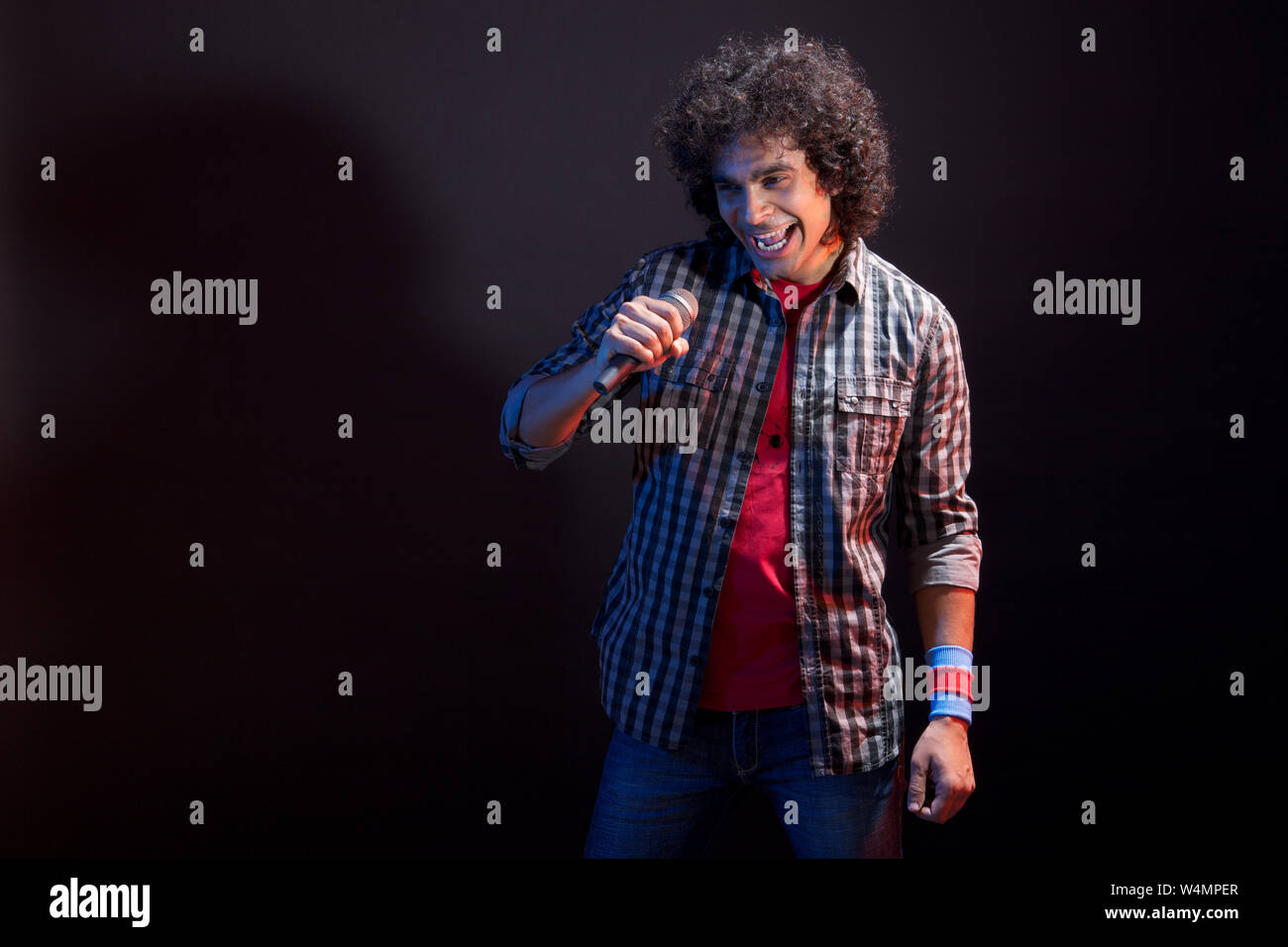 Man singing into microphone and smiling Stock Photo - Alamy