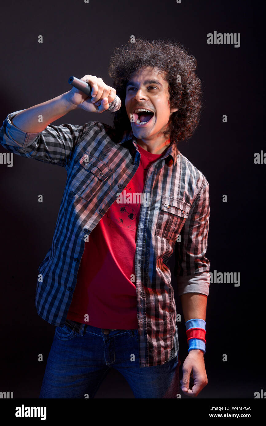 Man singing into microphone and smiling Stock Photo - Alamy