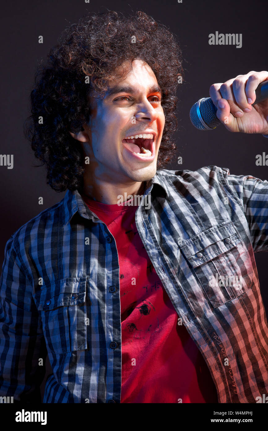 Indian man singing into microphone and smiling Stock Photo - Alamy
