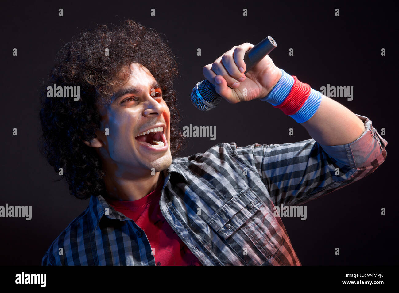 Man singing into microphone and smiling Stock Photo - Alamy