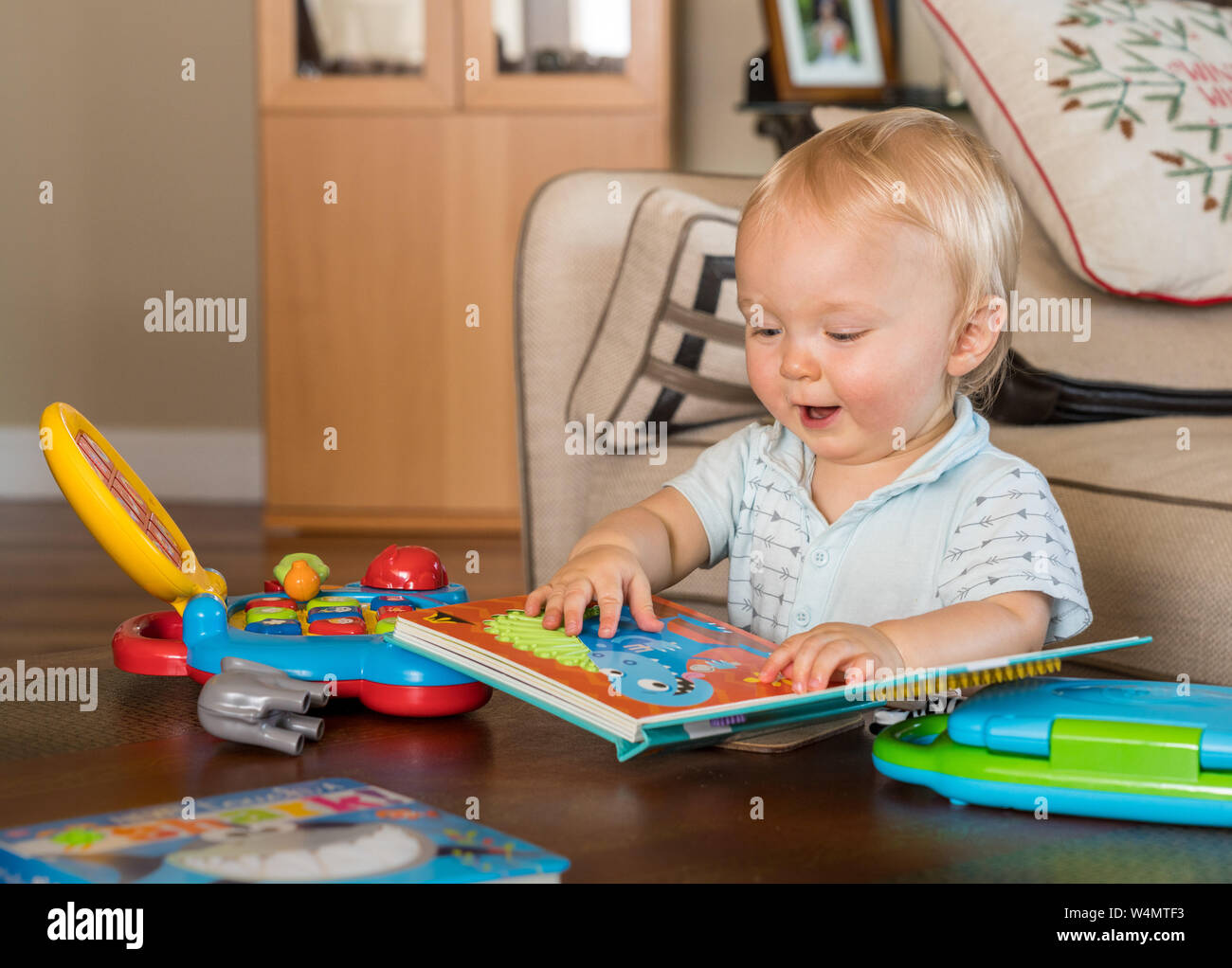Infant caucasian boy reading book rather than using computer Stock ...