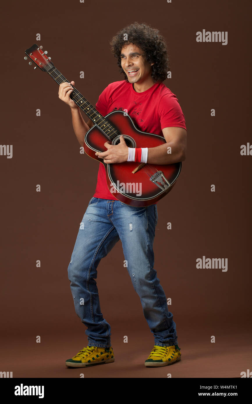 Man playing a guitar and smiling Stock Photo - Alamy