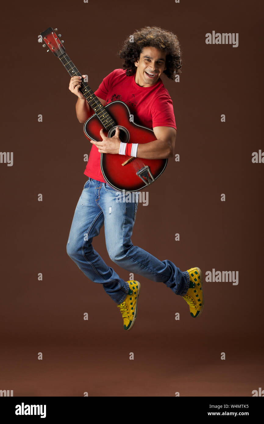 Man playing a guitar and smiling Stock Photo - Alamy