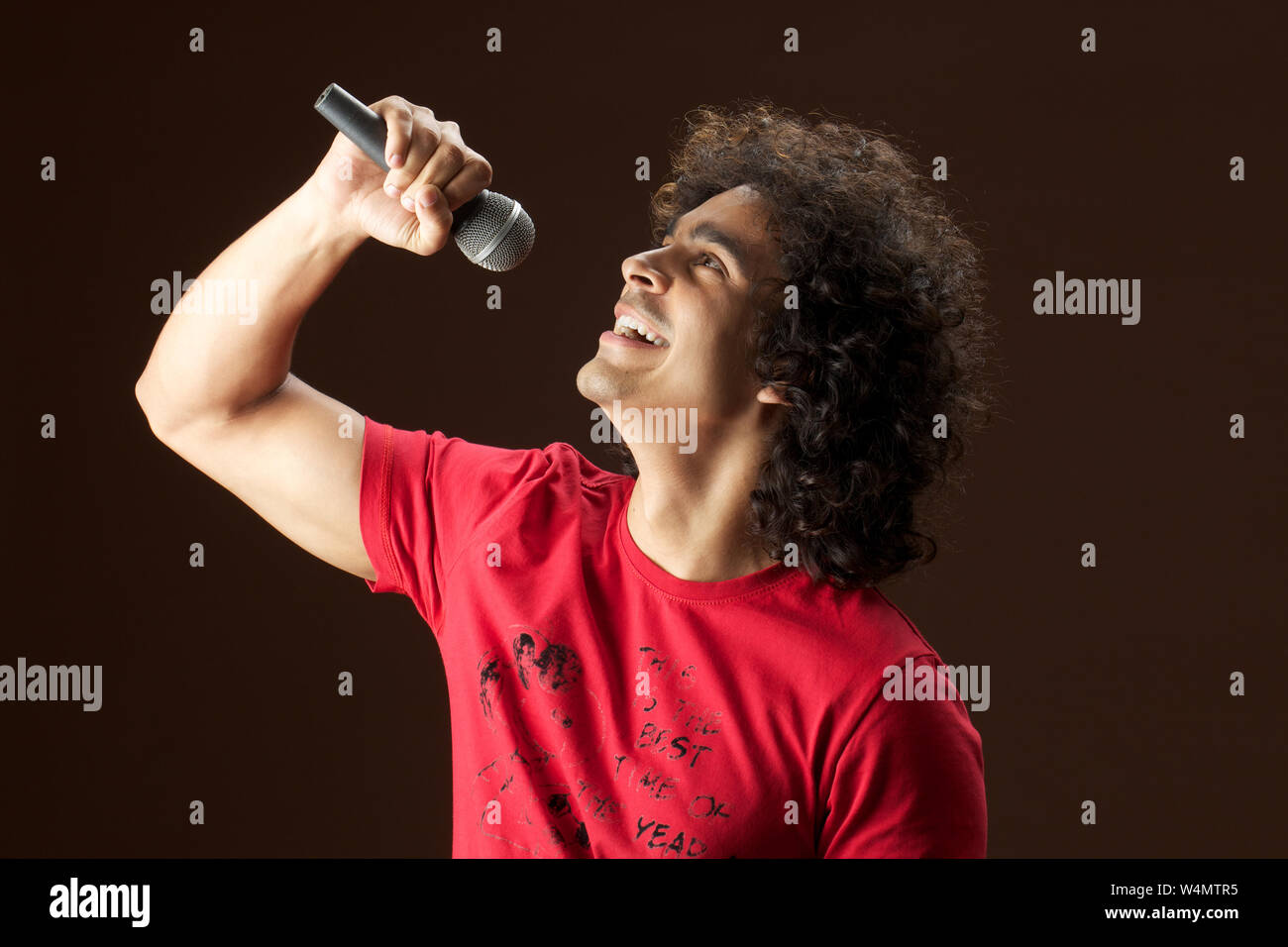 Man singing into microphone and smiling Stock Photo - Alamy
