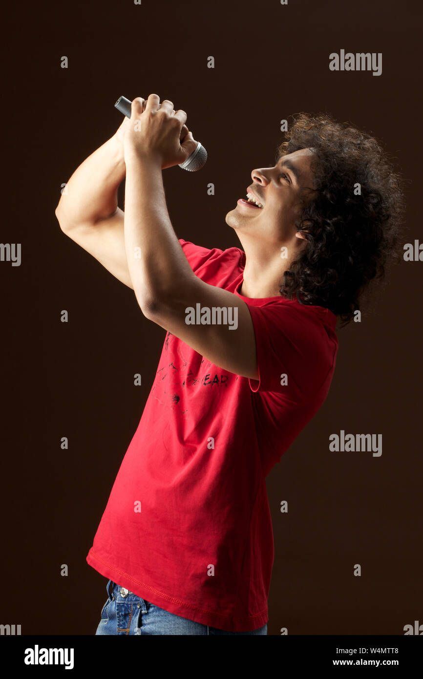 Man singing into microphone and smiling Stock Photo - Alamy