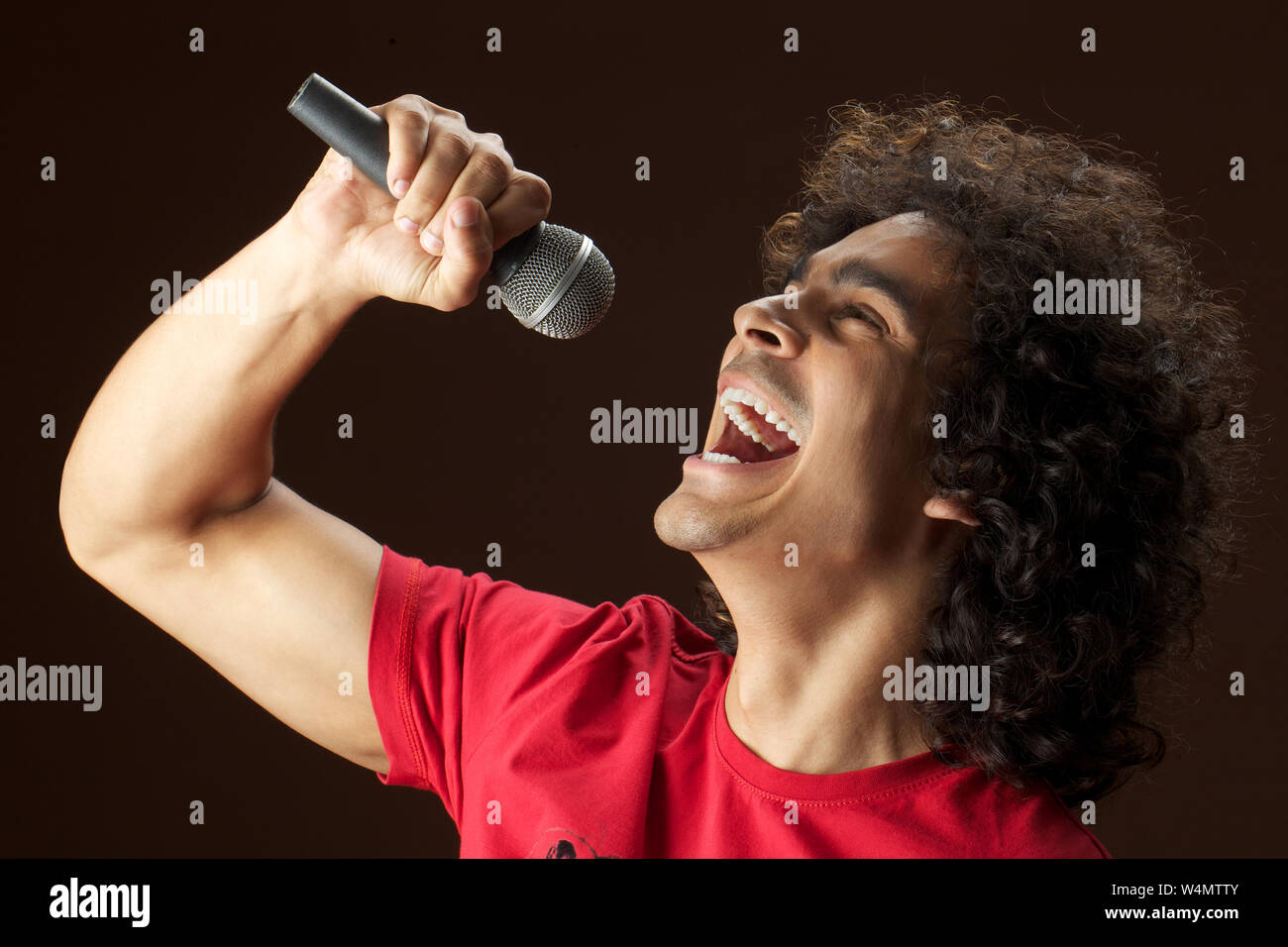 Indian man singing into microphone and smiling Stock Photo - Alamy